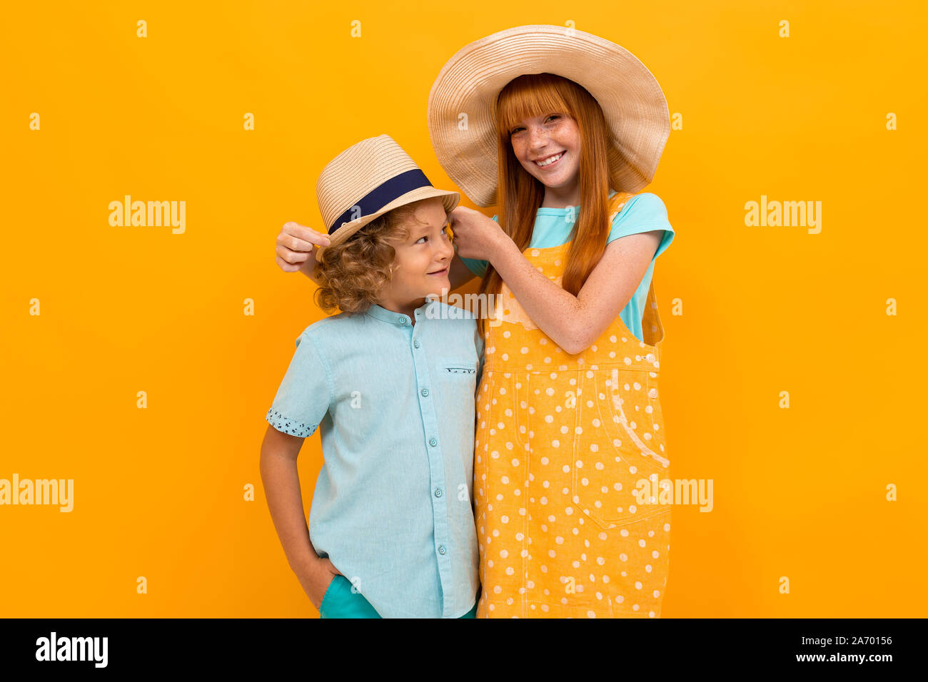 two beautiful children on an orange background stand hugging Stock ...