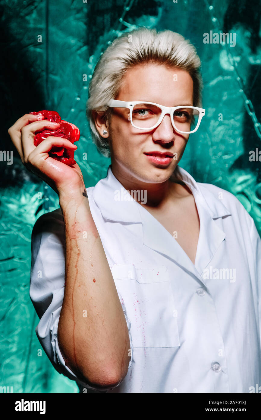 mad medical scientist in doctor's robe eats raw meat and enjoys ...