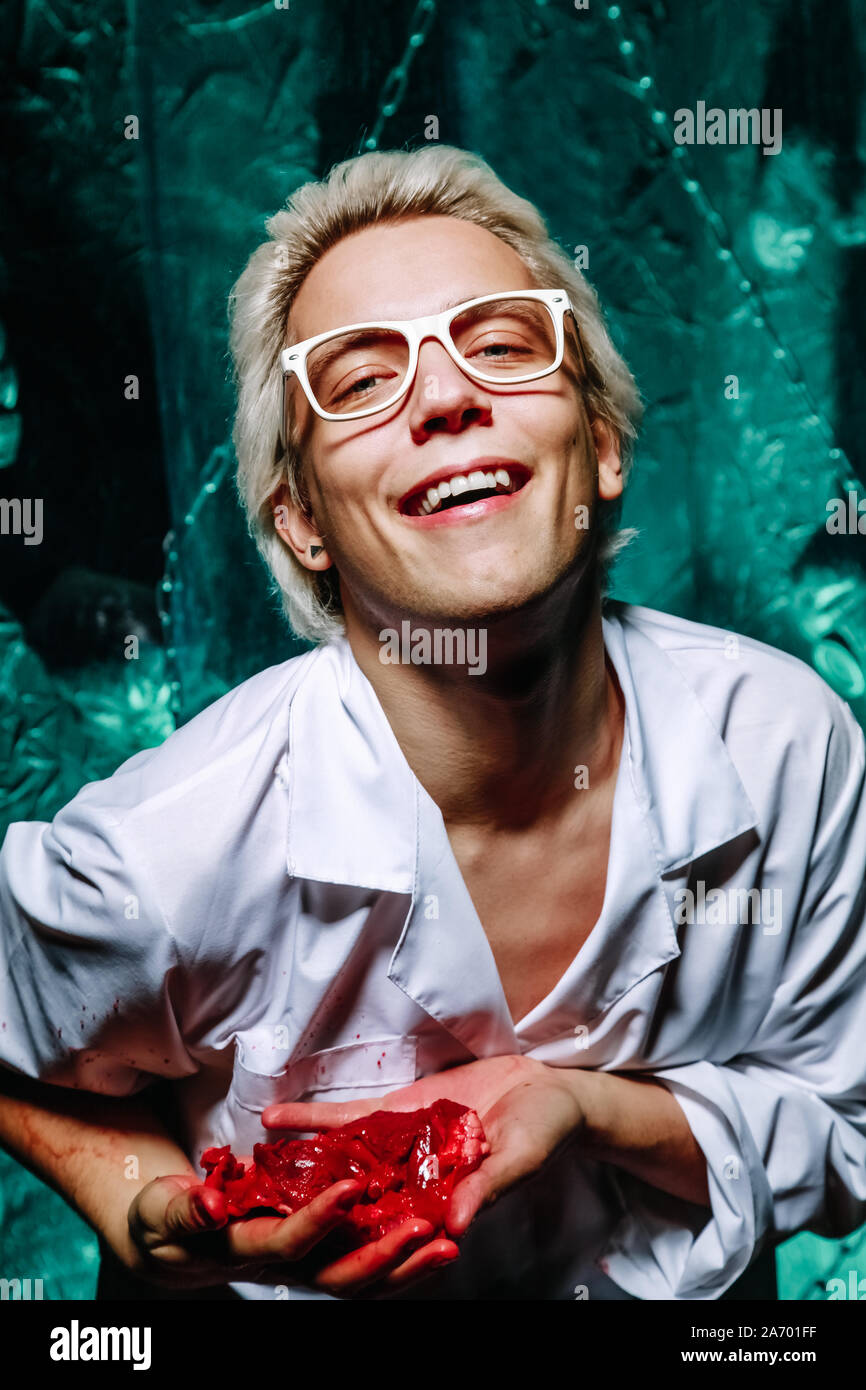 mad medical scientist in doctor's robe eats raw meat and enjoys ...