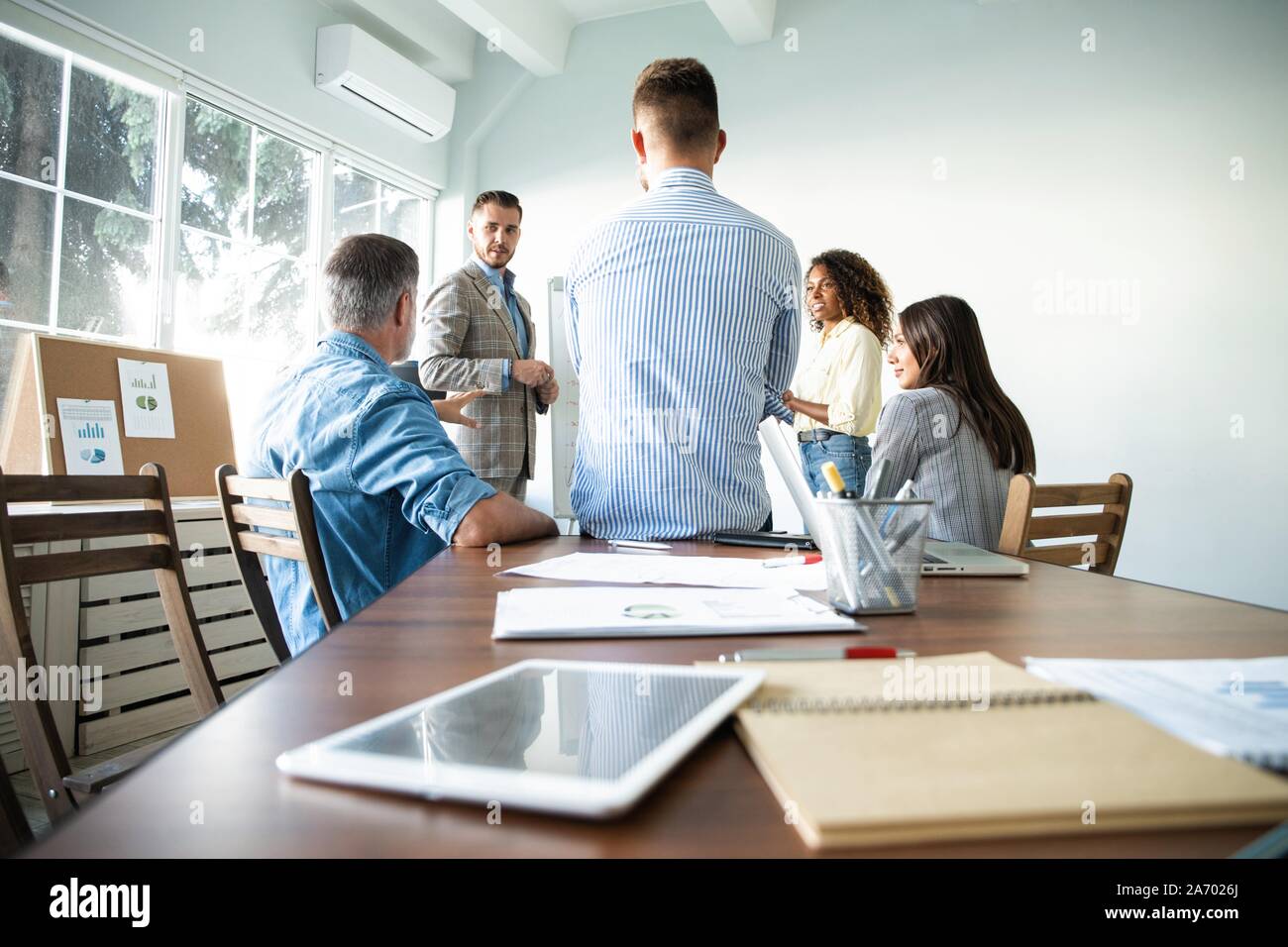 Group of young business people working and communicating while sitting ...
