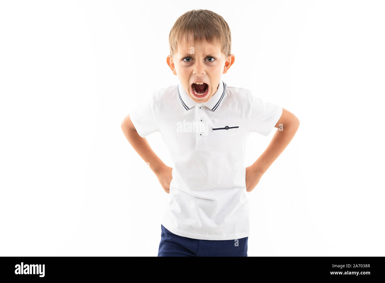 indignant boy stands with his mouth open and screams on a white ...