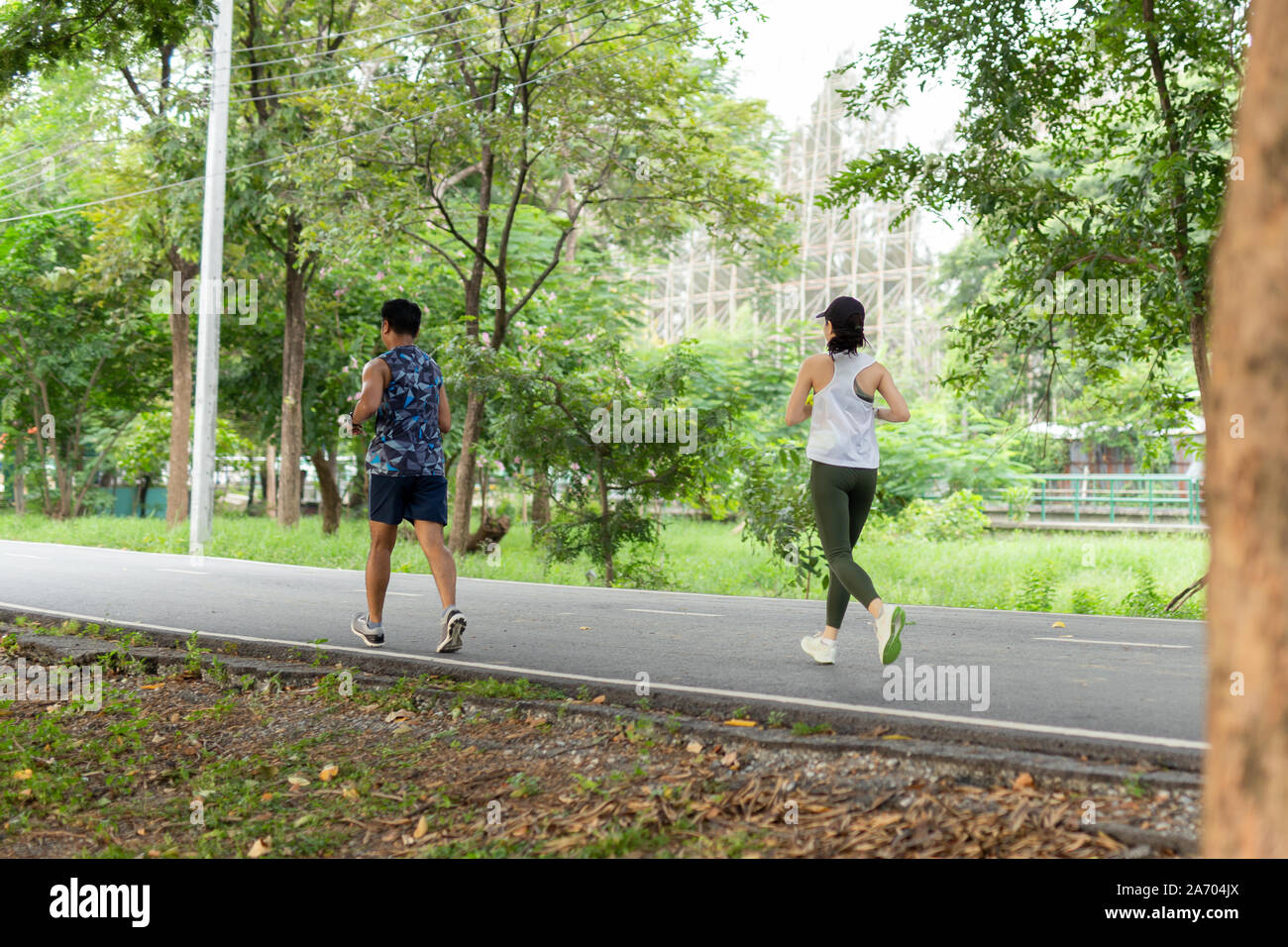Fitness sport woman and man running on the path trail in the park in ...