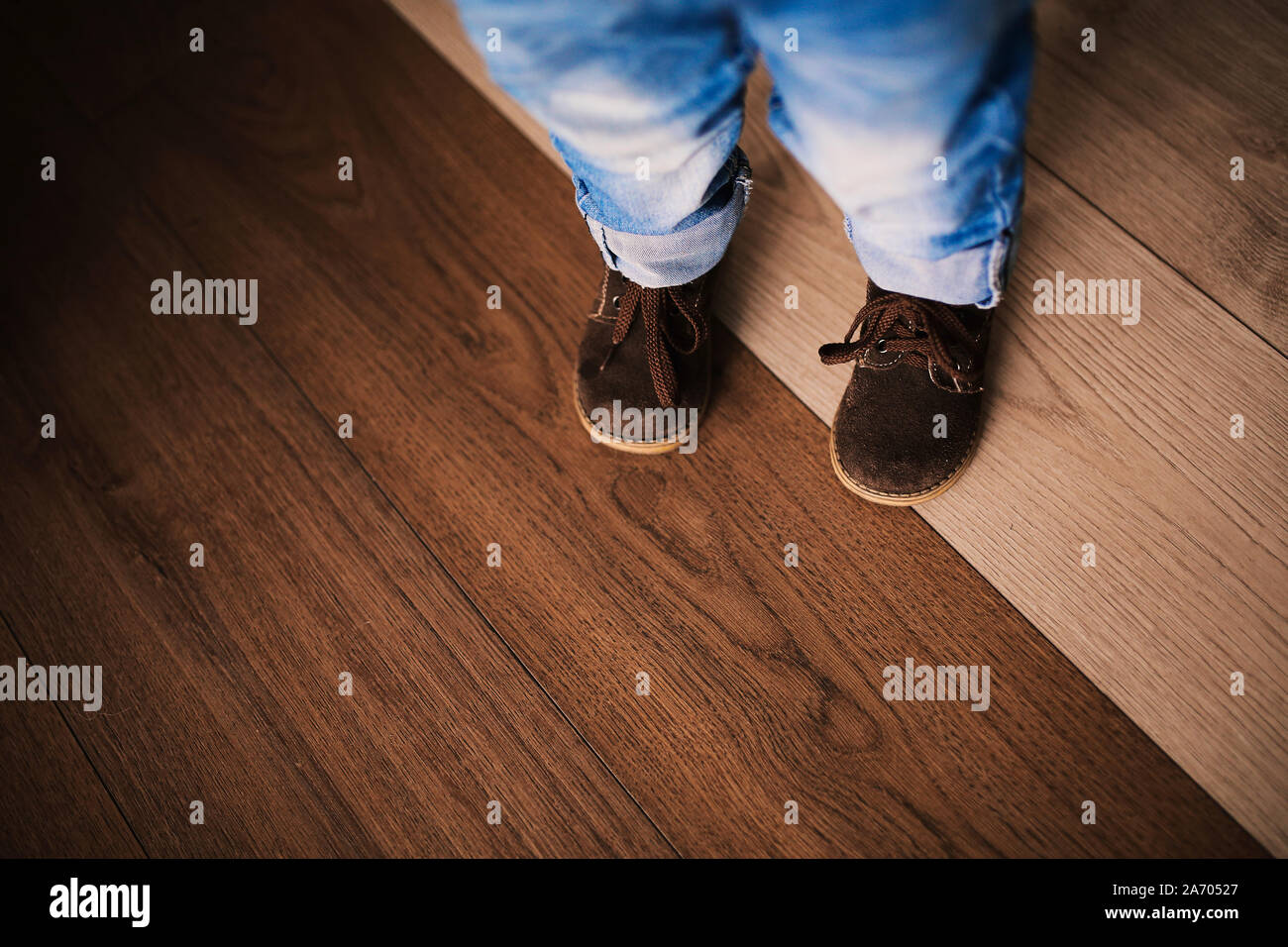 Baby's first steps. Background with the child's legs standing on the ...