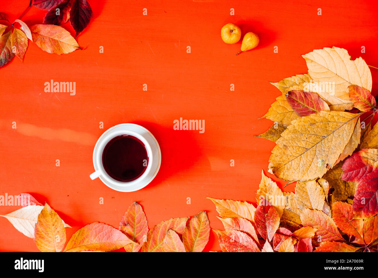 yellow autumn leaves Tea Cup on a red background Stock Photo - Alamy