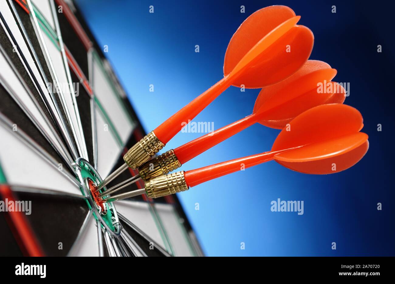 darts arrows in the target center Stock Photo - Alamy
