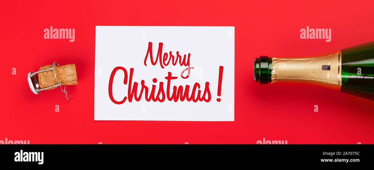 Christmas greeting card with champagne bottle over red background. Top ...