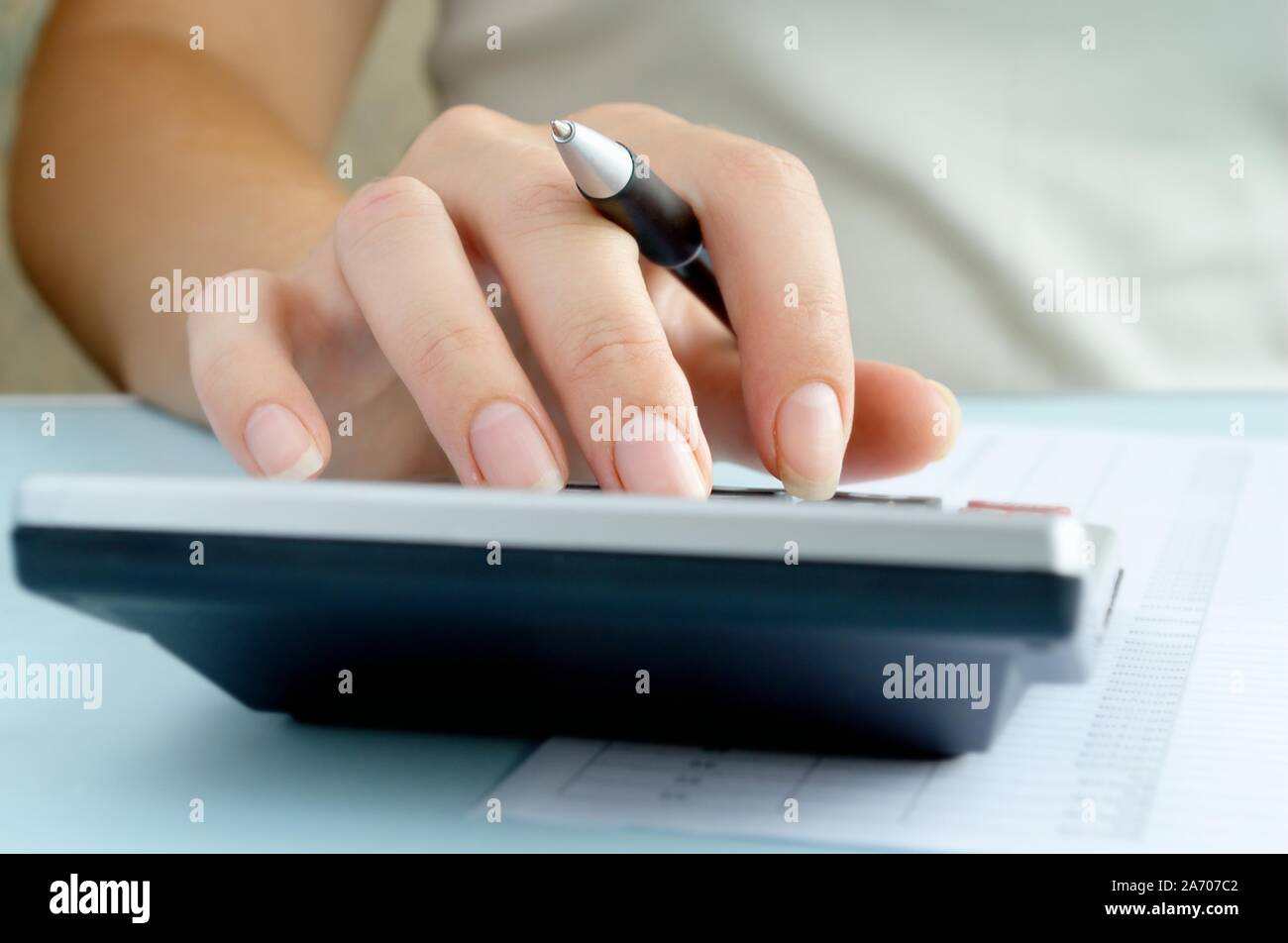 woman doing calculations on a calculator Stock Photo - Alamy