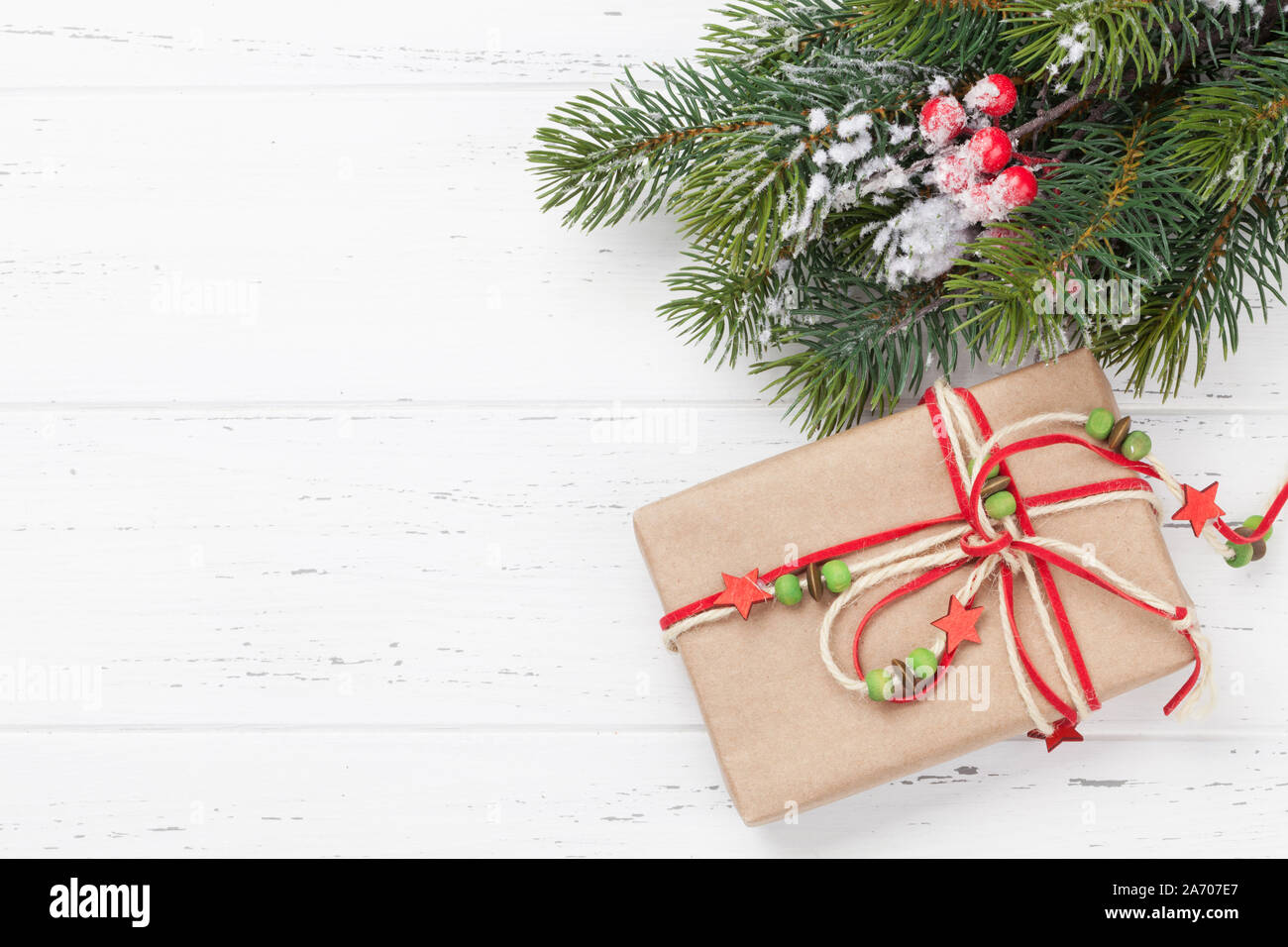 Christmas greeting card with gift box and fir tree branch over wooden ...