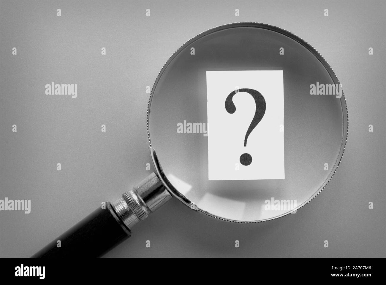 magnifying glass and a question mark on the paper Stock Photo - Alamy