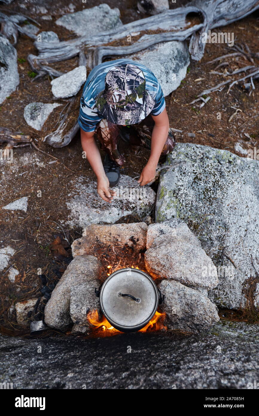 Man built a campfire in the woods in nature. Survive in the mountains ...