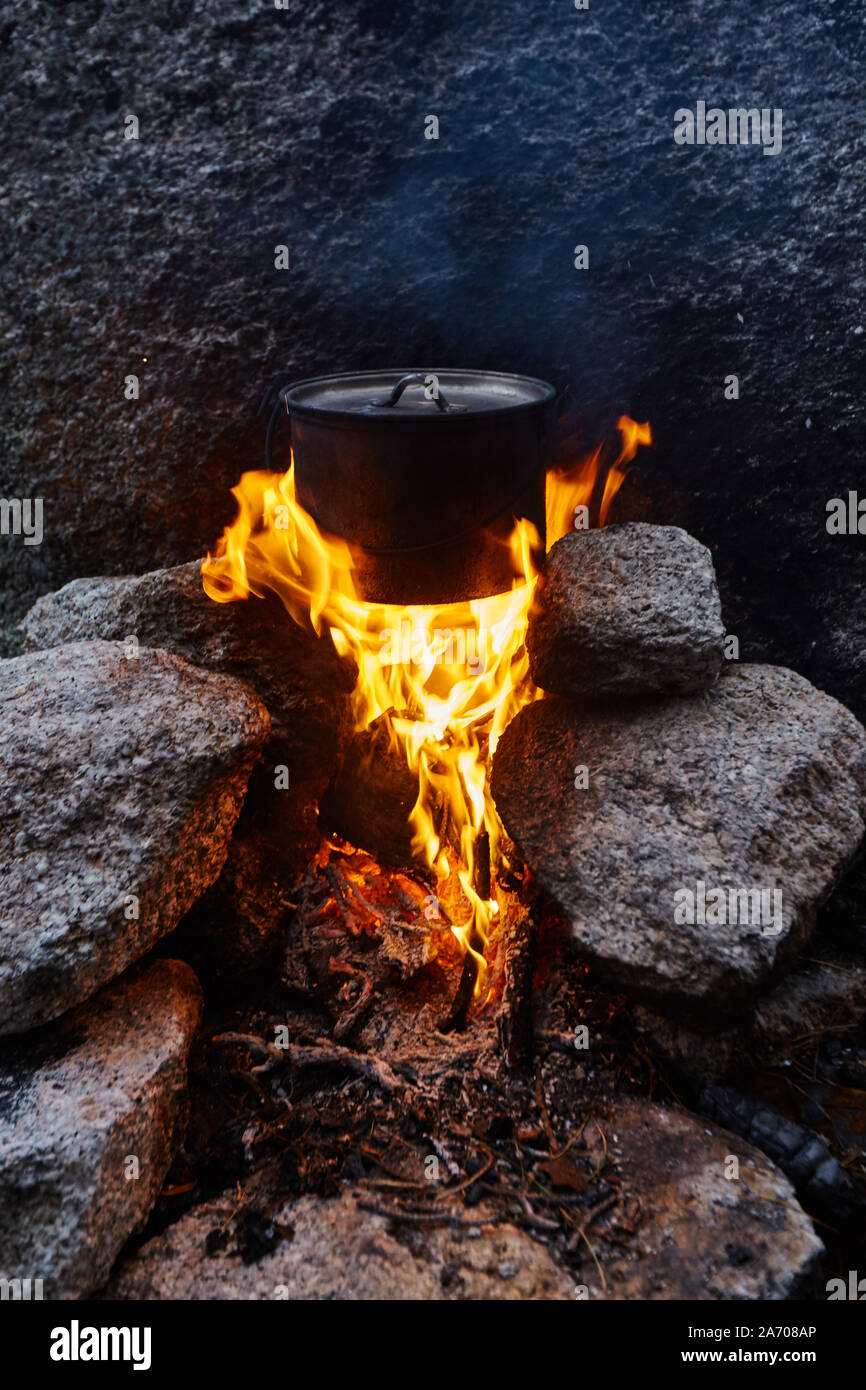 Man built a campfire in the woods in nature. Survive in the mountains ...