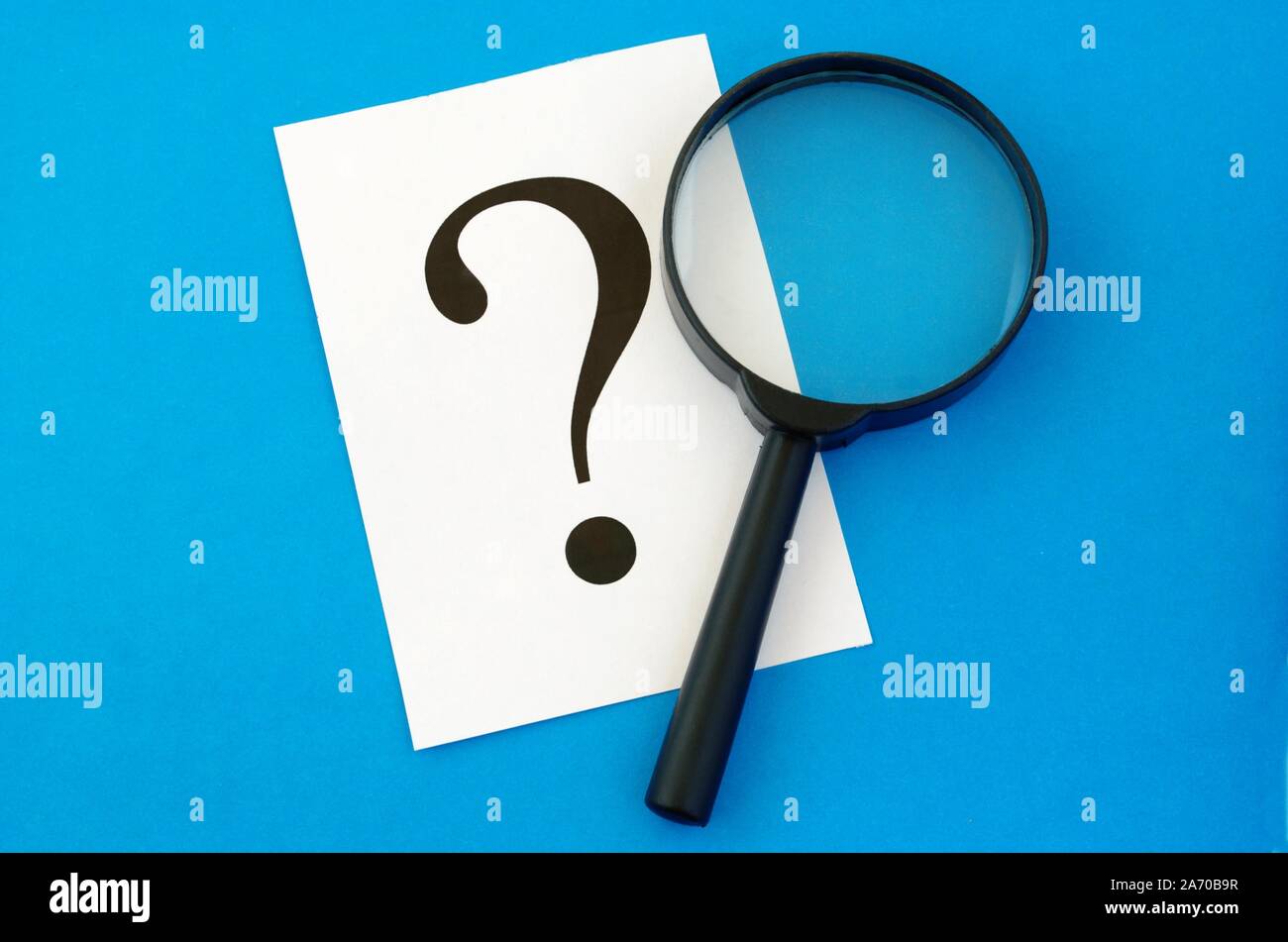 question mark on the paper and a magnifying glass Stock Photo - Alamy
