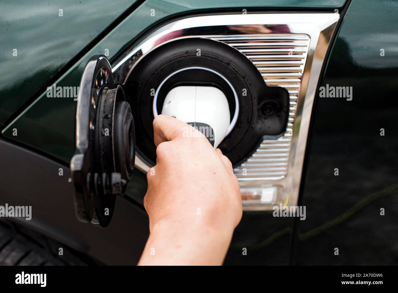 hand plugging in an electric car Stock Photo - Alamy