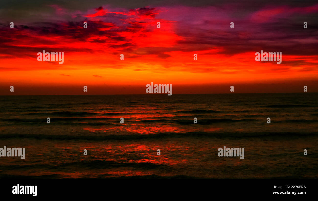 Sunrise over the sea. Fiery red sky and metallic gray water. Bright ...