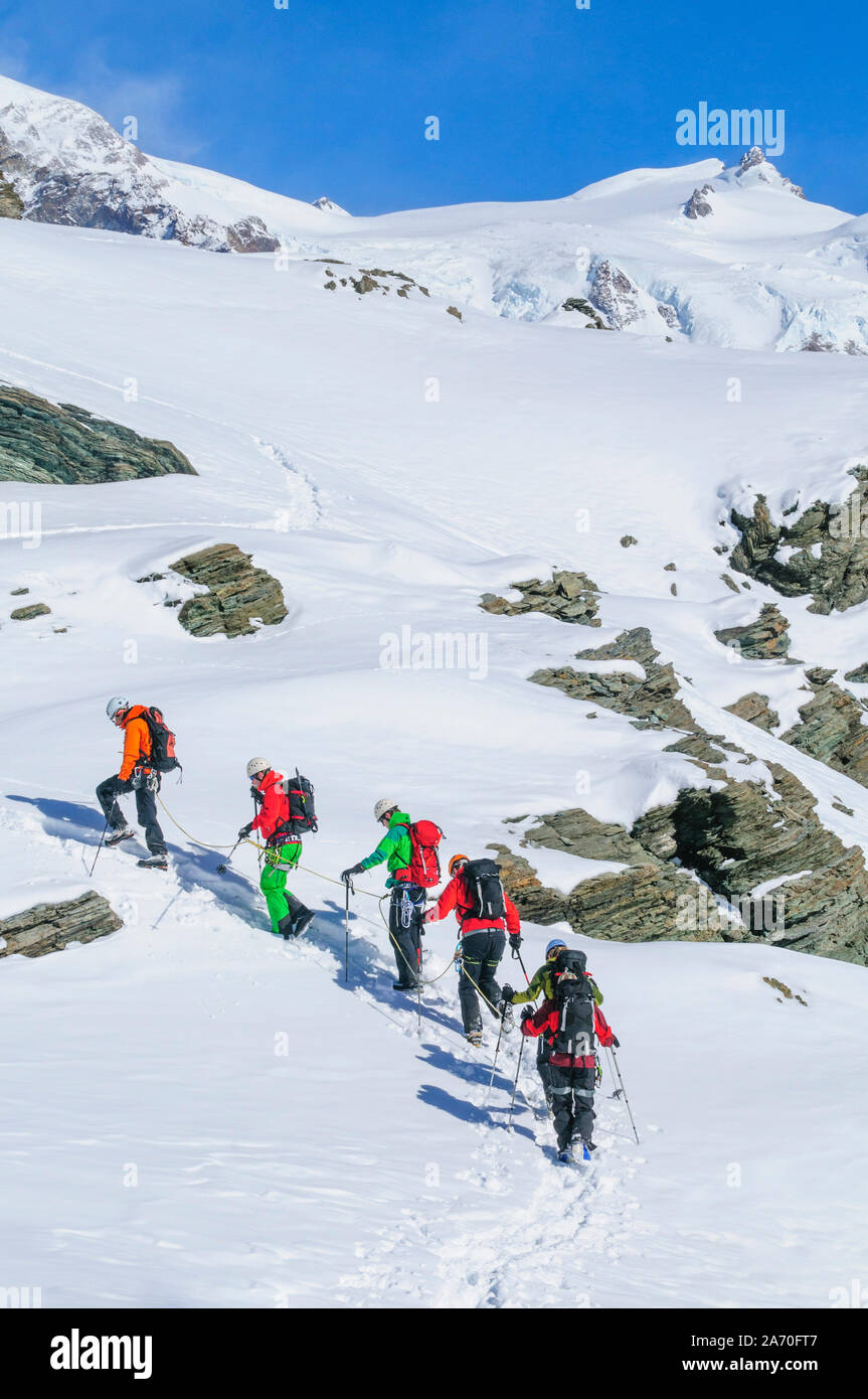 Rope team ascending to mountain top in high alpine region of Monte Rosa ...
