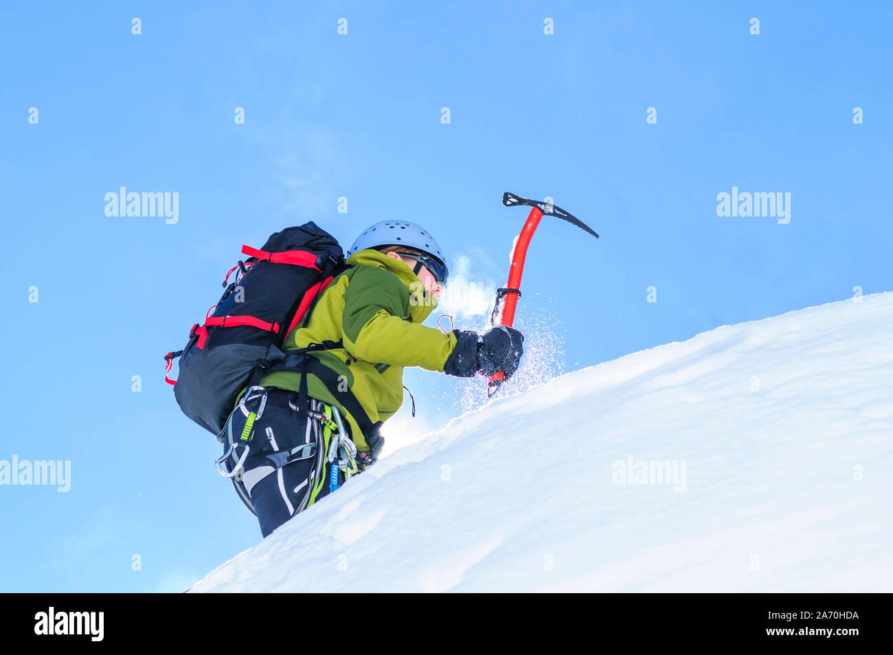 Alpinists climbing in steep and snowy mountains using an ax Stock Photo ...