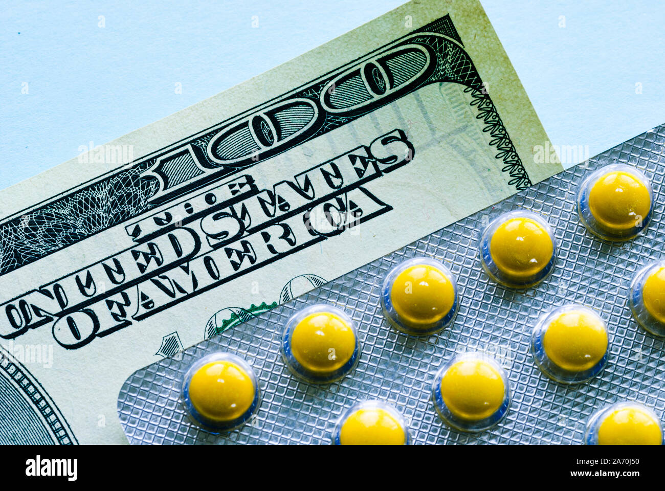 Yellow pills in blister on one hundred US dollars bill banknote in ...