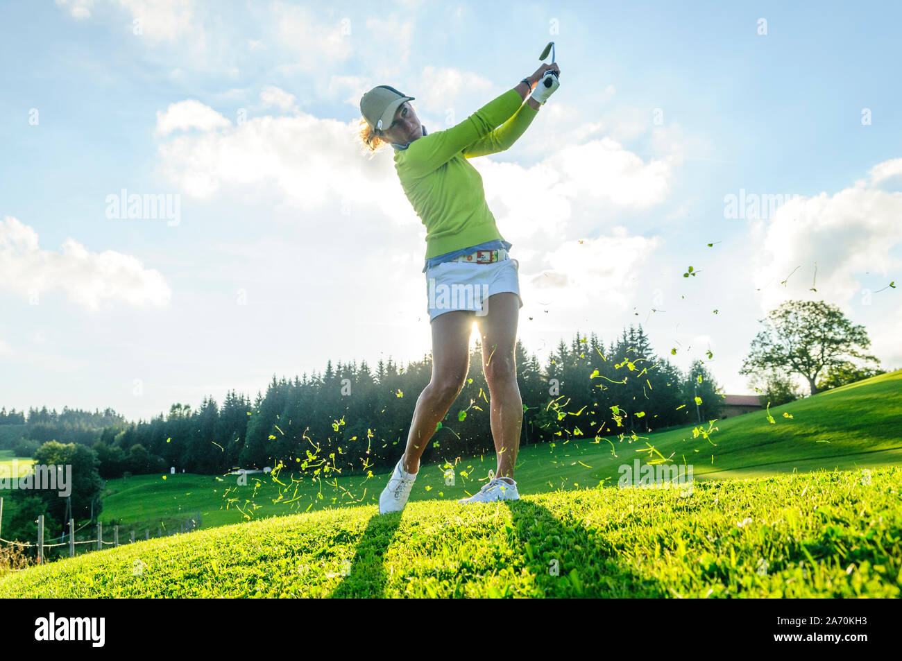 Playing golf in bavarian Allgäu at a sunny late afternoon in summertime ...