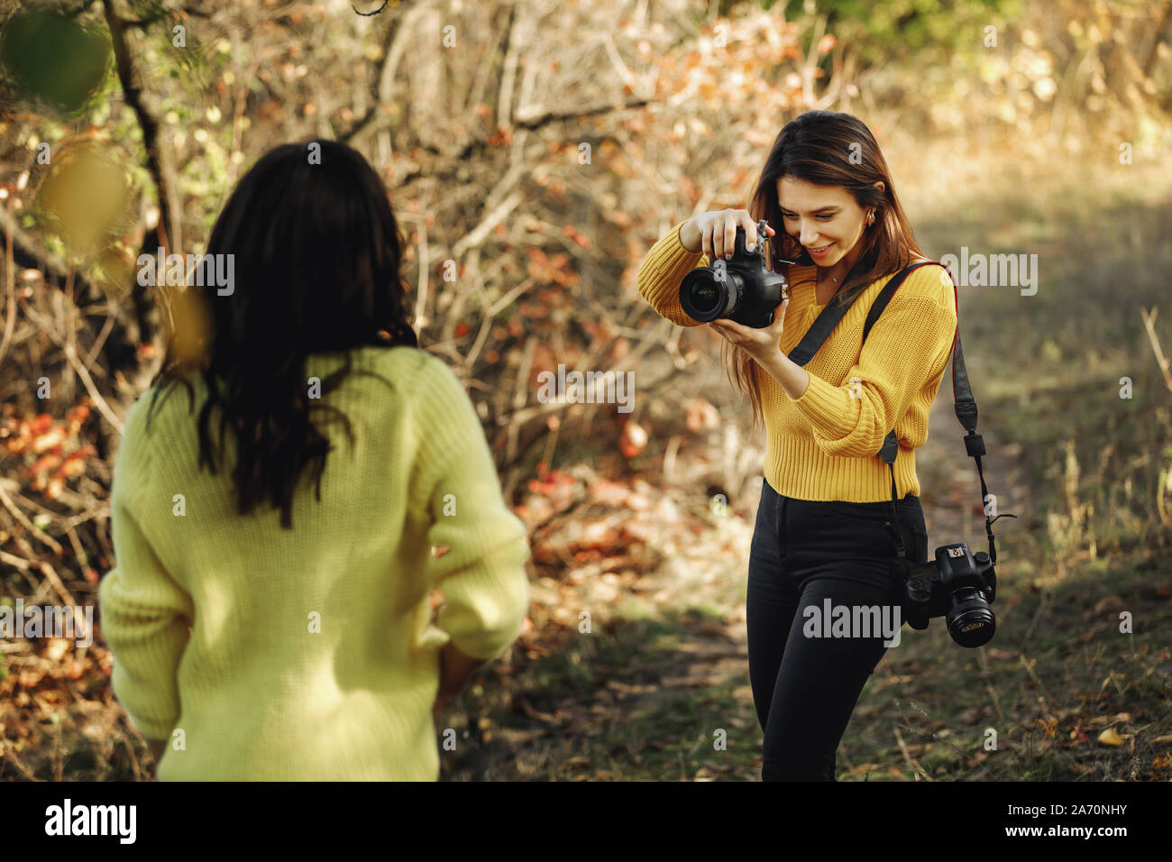 young woman photographer takes pictures of model in nature, the ...