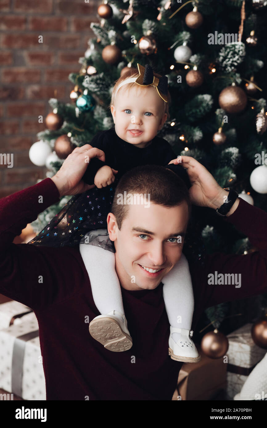 Cute little girl sitting on father's neck Stock Photo - Alamy