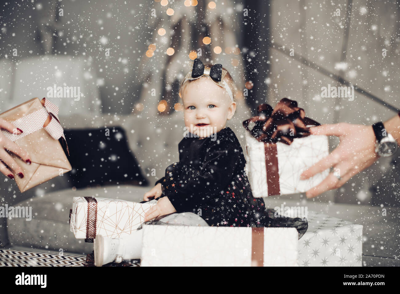 Adorable baby girl with Christmas presents. Father and mother giving ...
