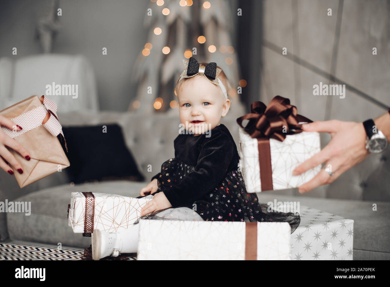 Adorable baby girl with Christmas presents. Father and mother giving ...