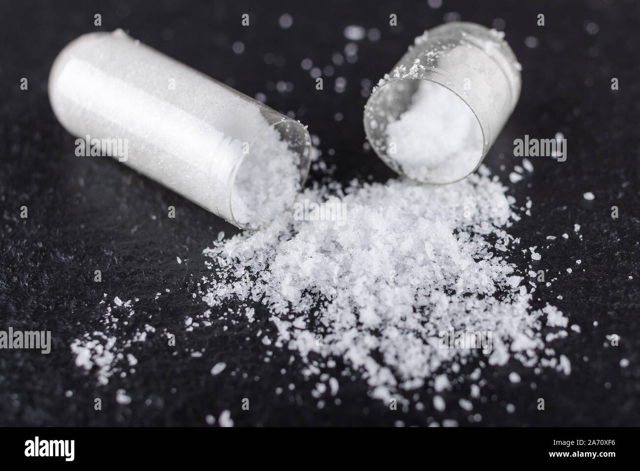 one open capsule of msm, sulfur, methyl sulfonyl methan on black ...