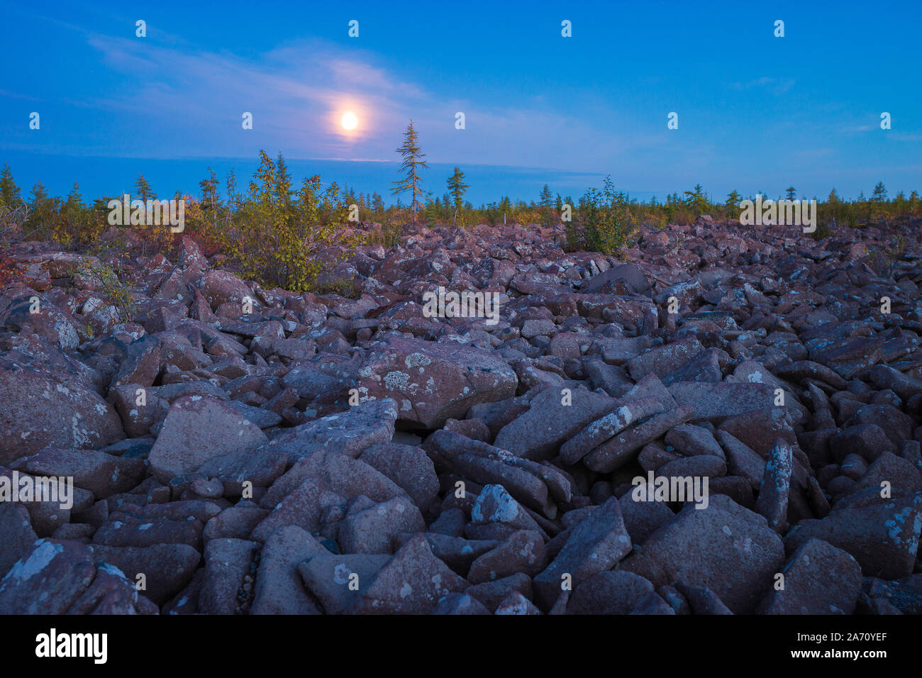 Summer night landscape with forest, cliffs and white clouds on the blue ...