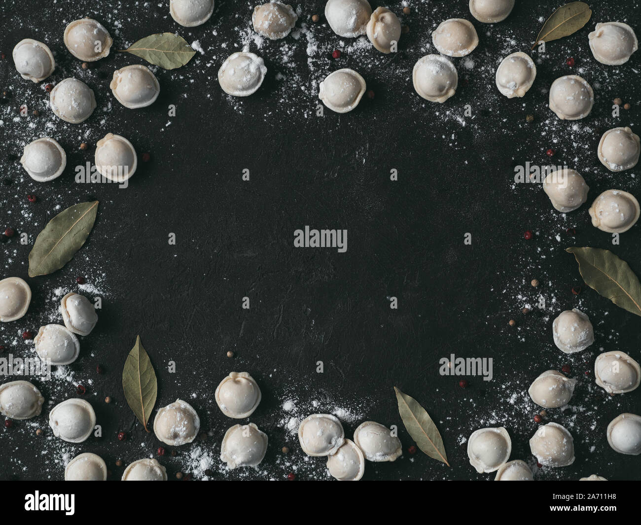 Pattern of frozen uncooked russian pelmeni with peppercorns and bay ...