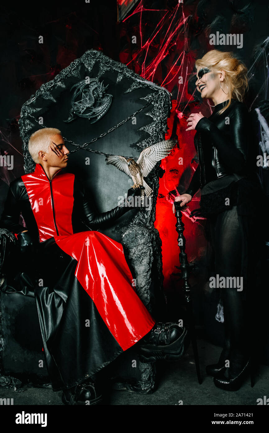 Gothic friends with dark make up in rock outfits on a huge scary throne ...