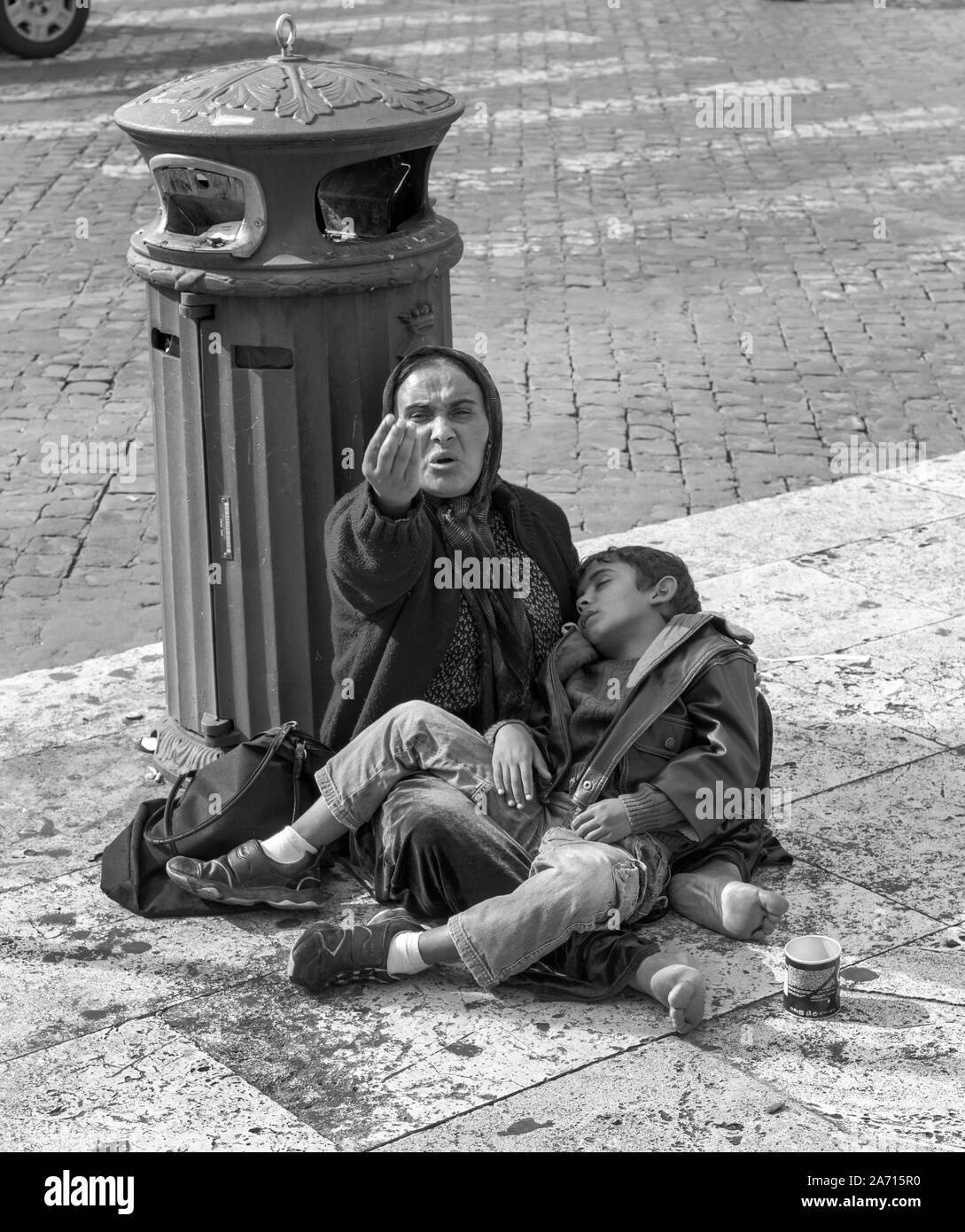 Woman with a child begging on the street at St Peter's Square, Rome ...