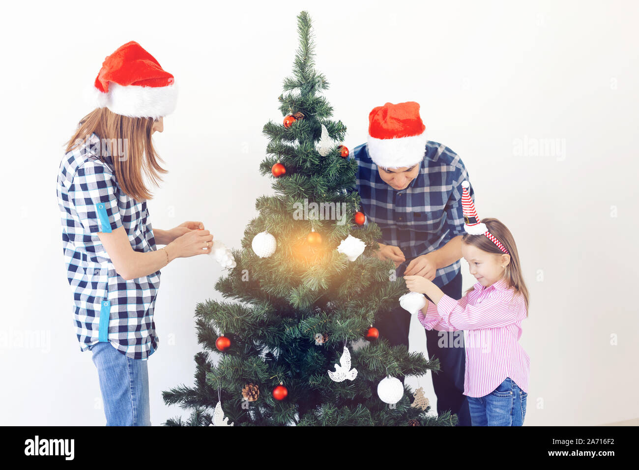 Holidays, parents and celebrating concept - Happy family decorating a ...