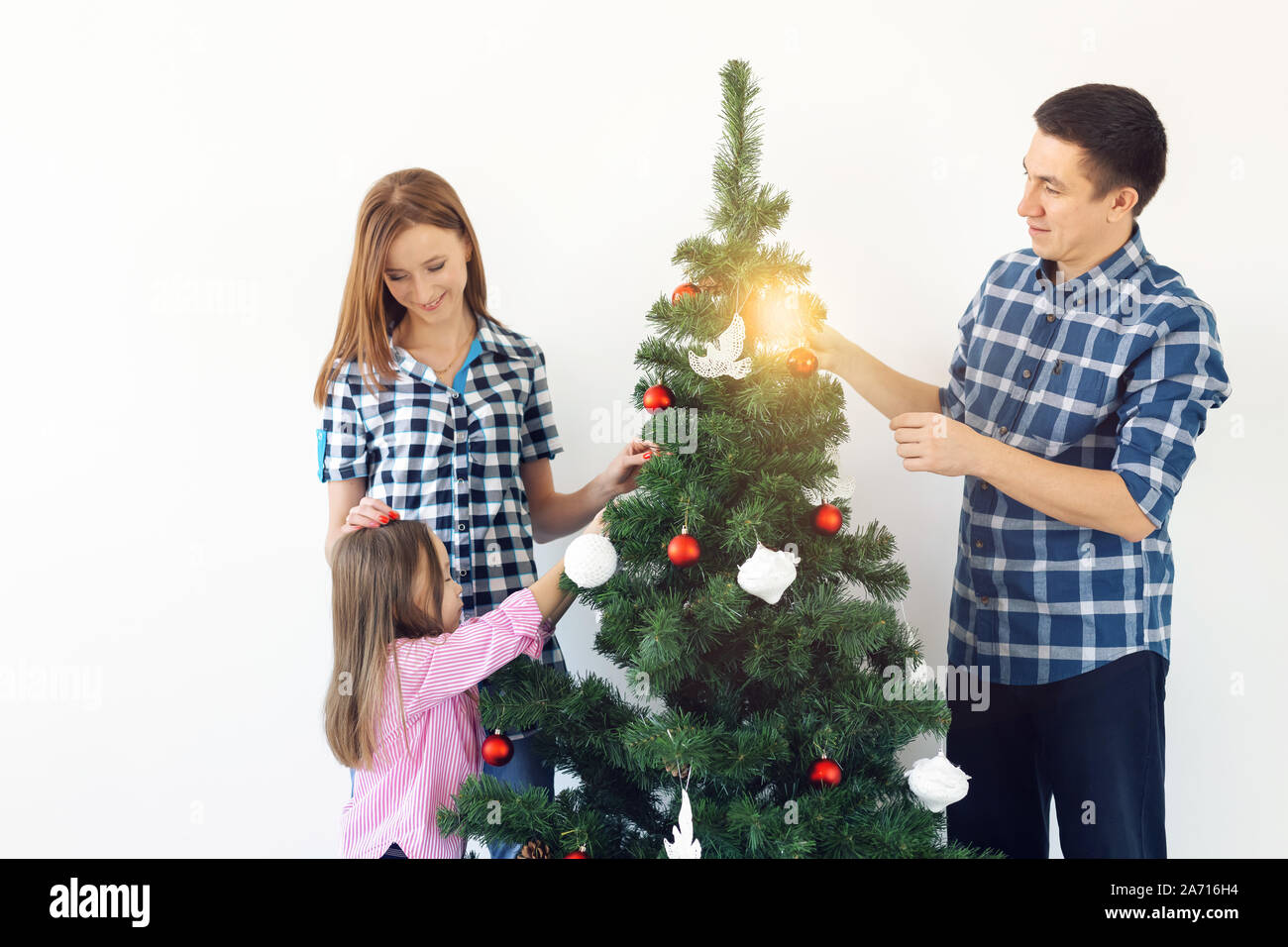 Holidays, parents and celebrating concept - Happy family decorating a ...