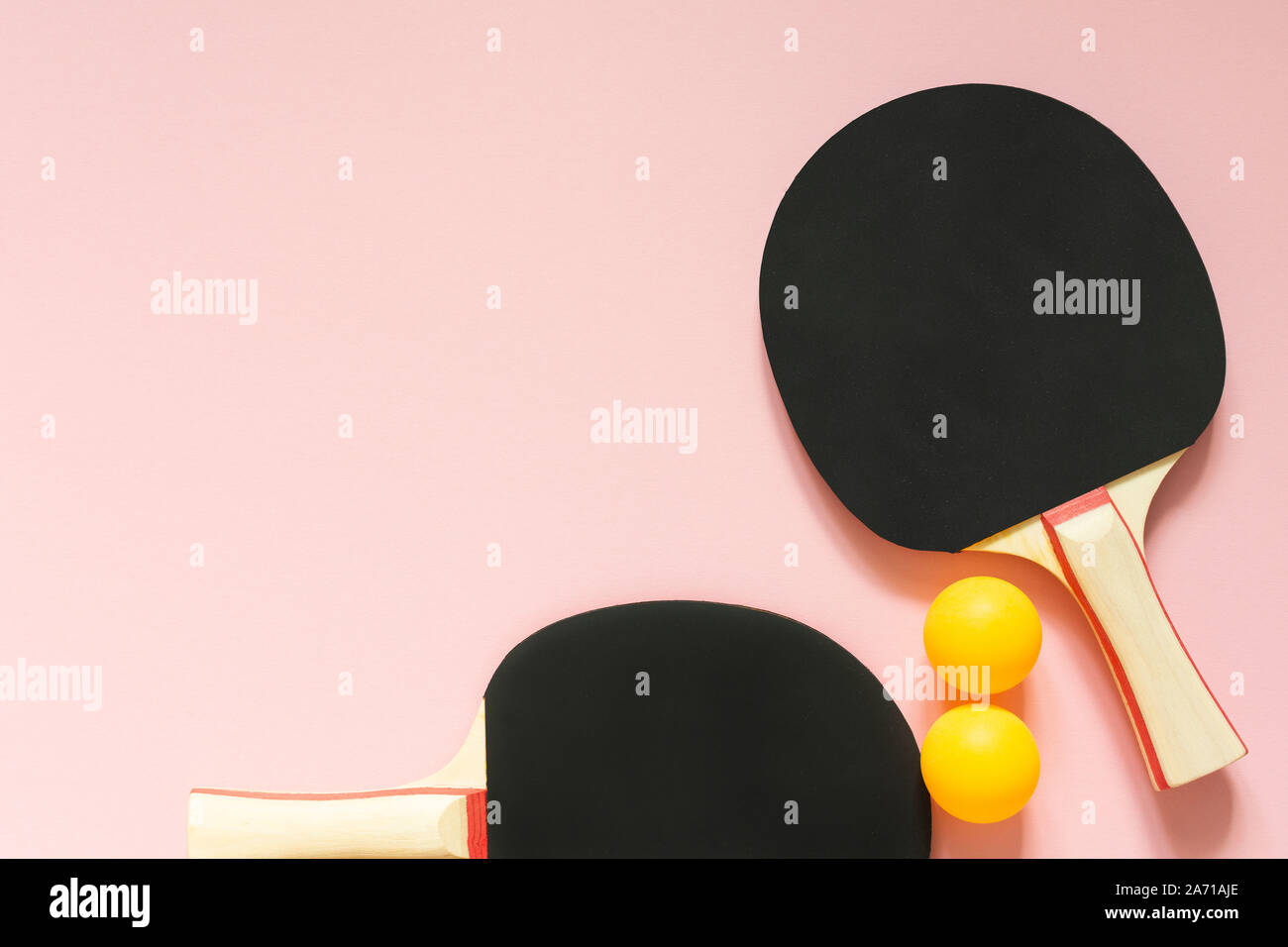 Black tennis ping pong rackets and orange balls isolated on a pink ...