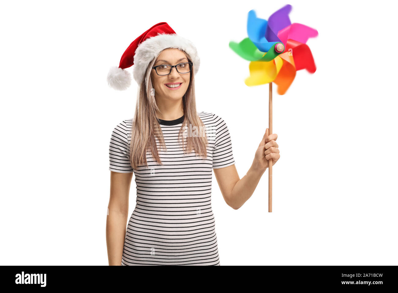 Young woman with a spinning pinwheel wearing a Santa hat isolated on ...