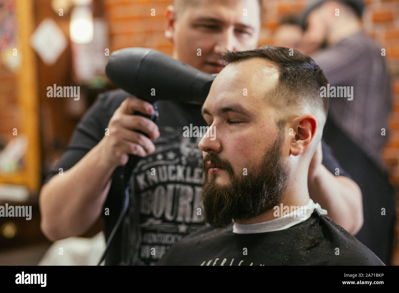 Barber shop, a man with a beard cut hairdresser. Professional haircut ...