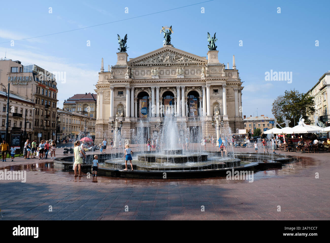 People playing around fountain on a hot day in front on the Opera house ...