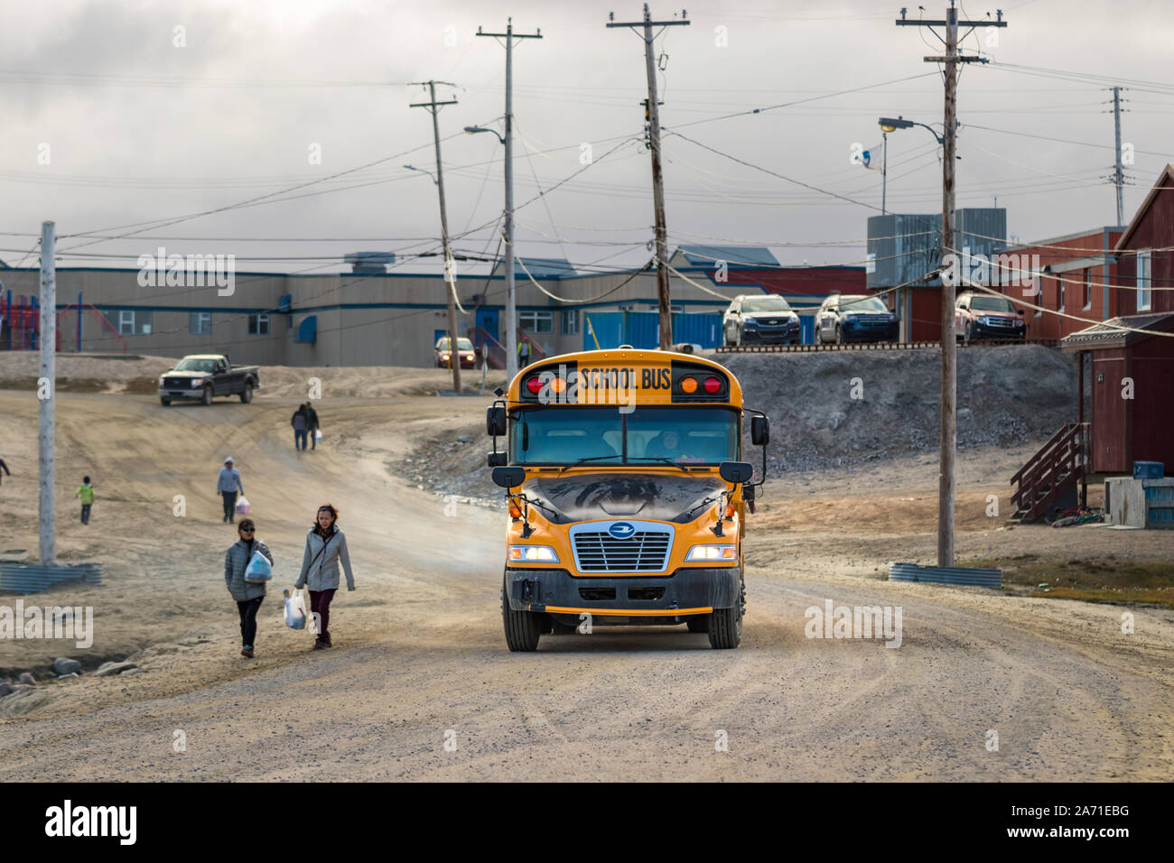 A school yellow bus on a dirt road in Clyde River, Nunavut, Canada ...