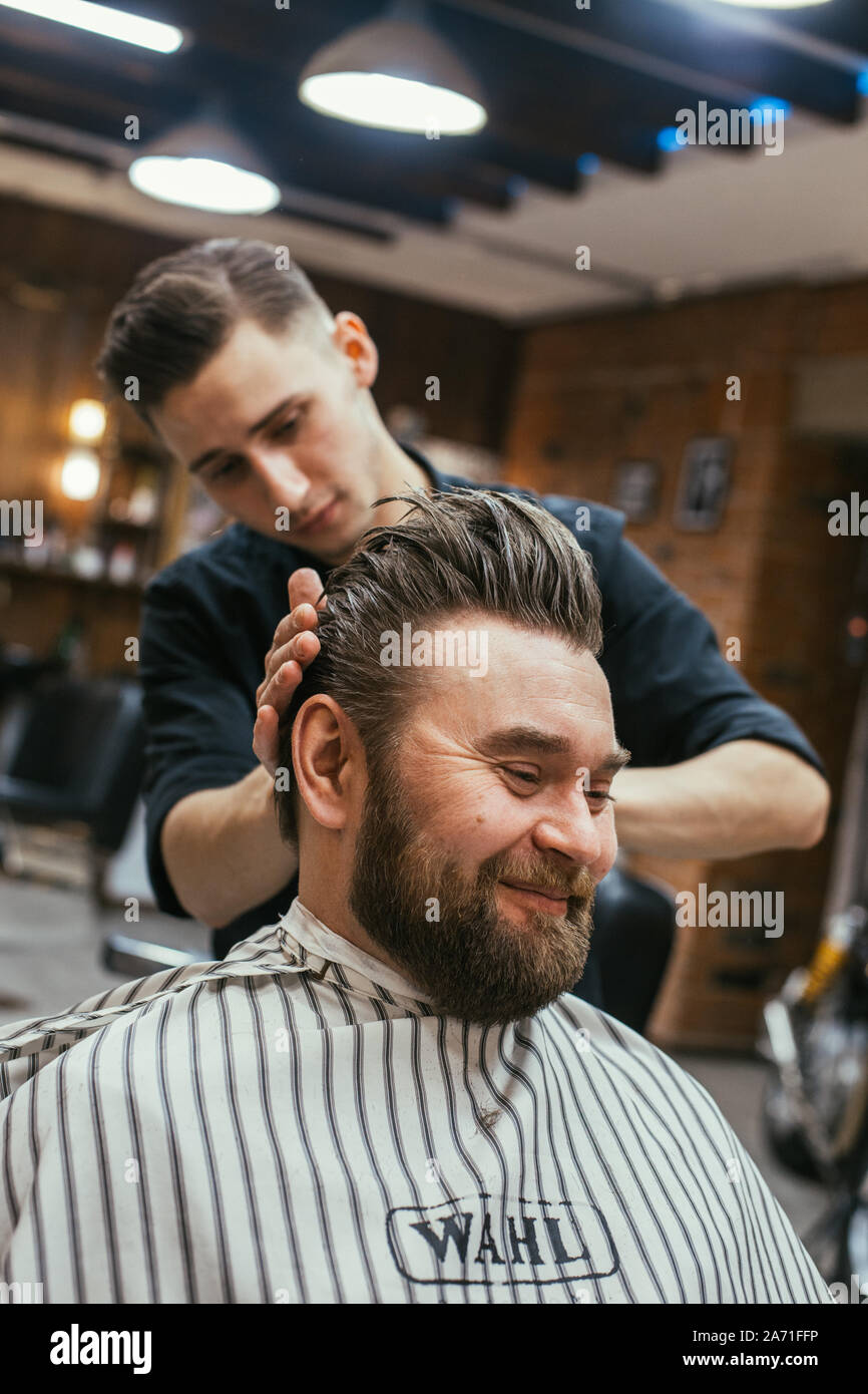 Barber shop, a man with a beard cut hairdresser. Beautiful hair and ...