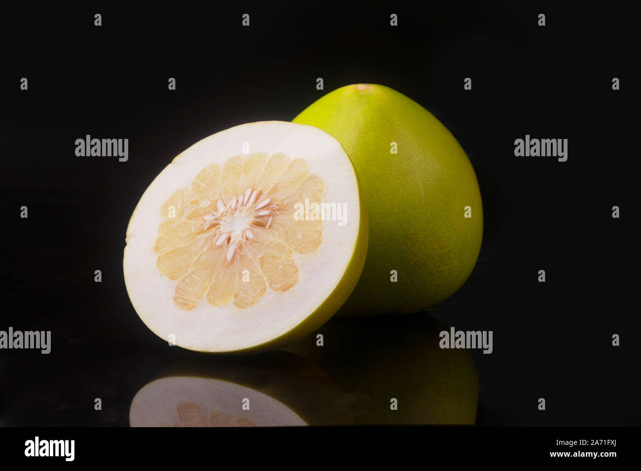 One pomelo and half sliced pomelo fruit on black background with ...