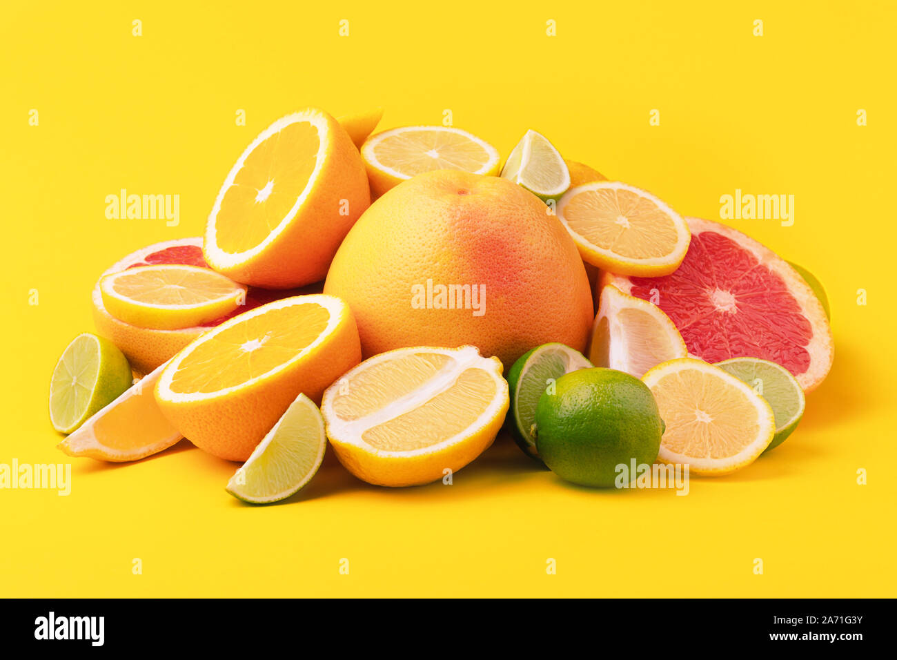 Citrus fruits (orange, lemon, grapefruit, lime) on yellow background ...
