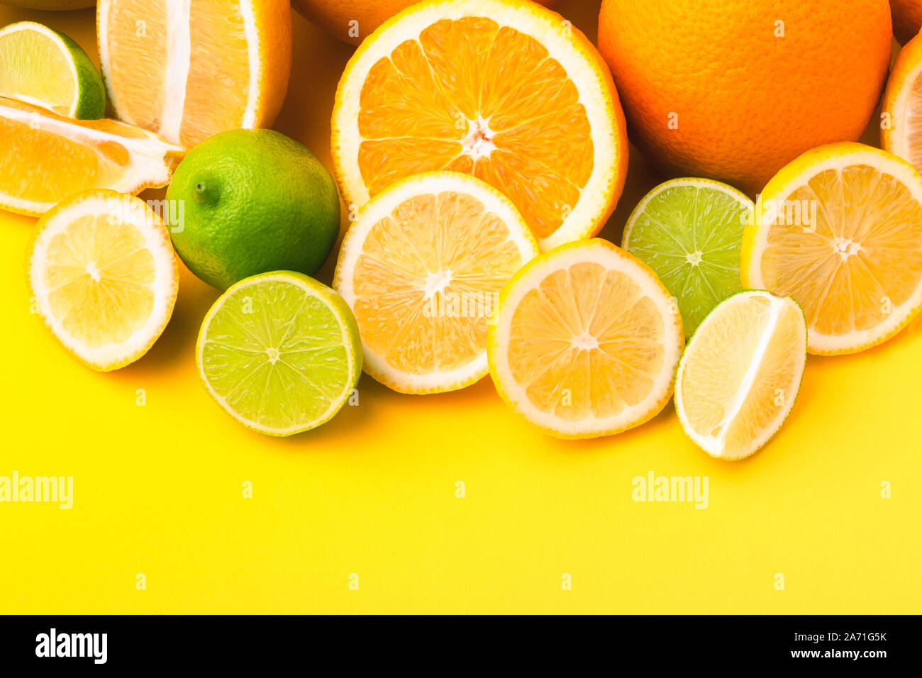 Citrus fruits (orange, lemon, grapefruit, lime) on yellow background ...