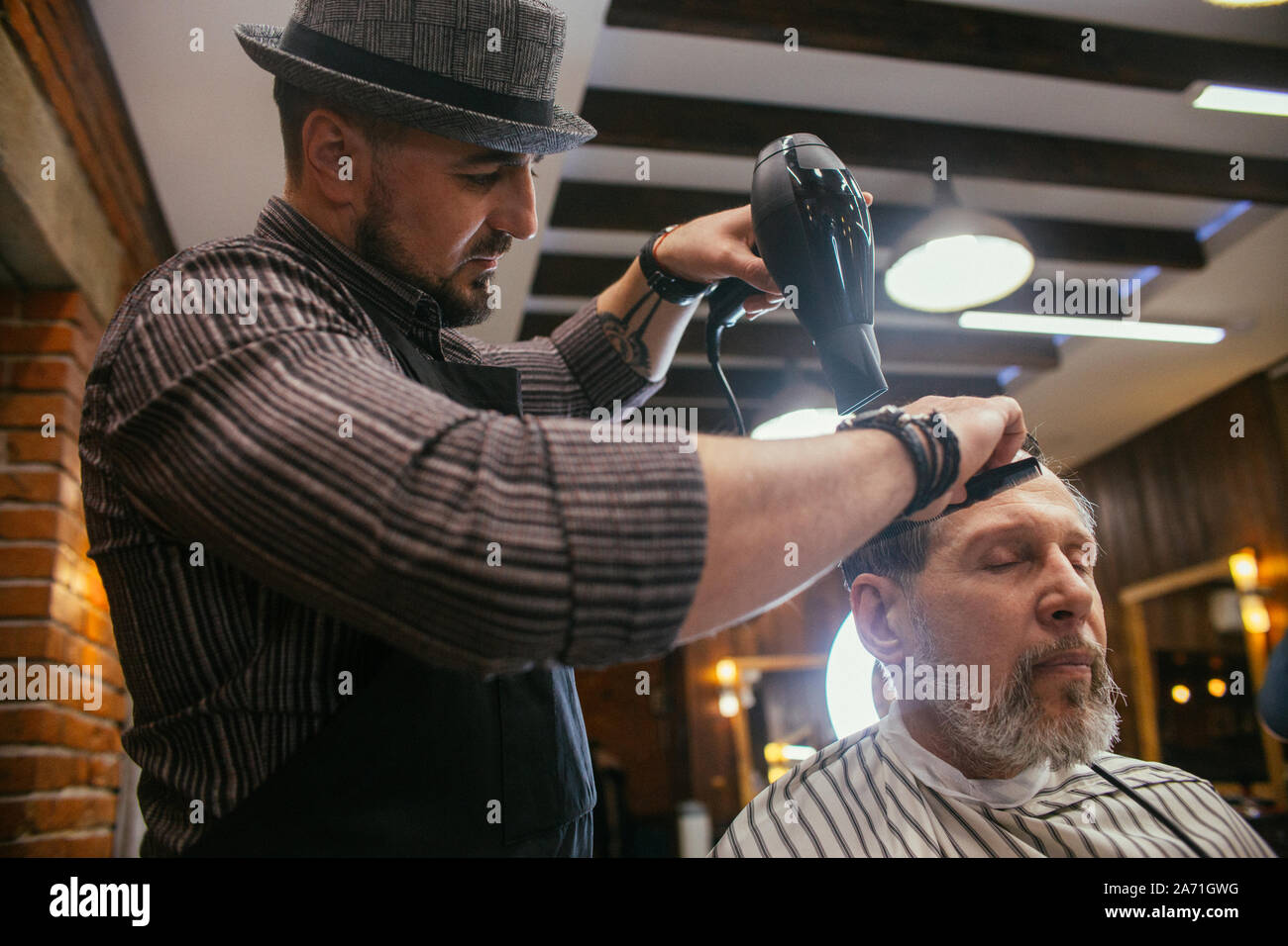 Grandpa gets a haircut at the hairdresser in Barber shop. Trendy ...