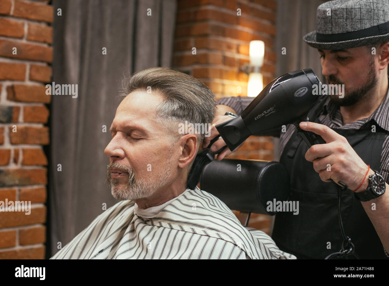 Grandpa gets a haircut at the hairdresser in Barber shop. Trendy ...