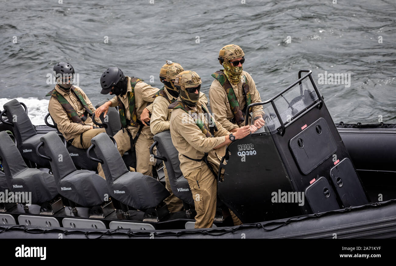 Close up of Water Police in camoflauge on high speed RIB on ...