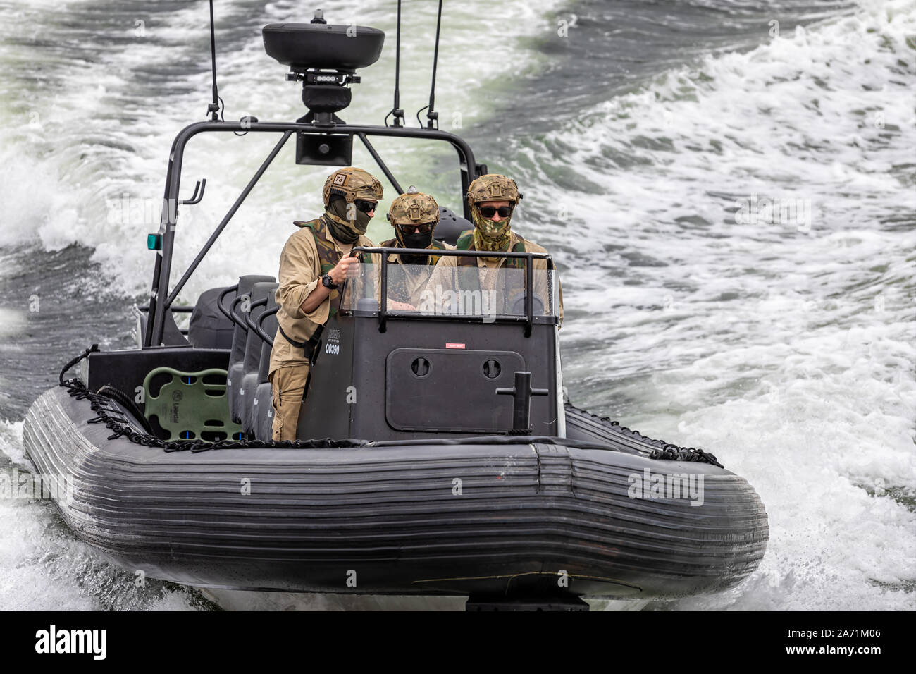 Close up of Water Police in camoflauge on high speed RIB on ...
