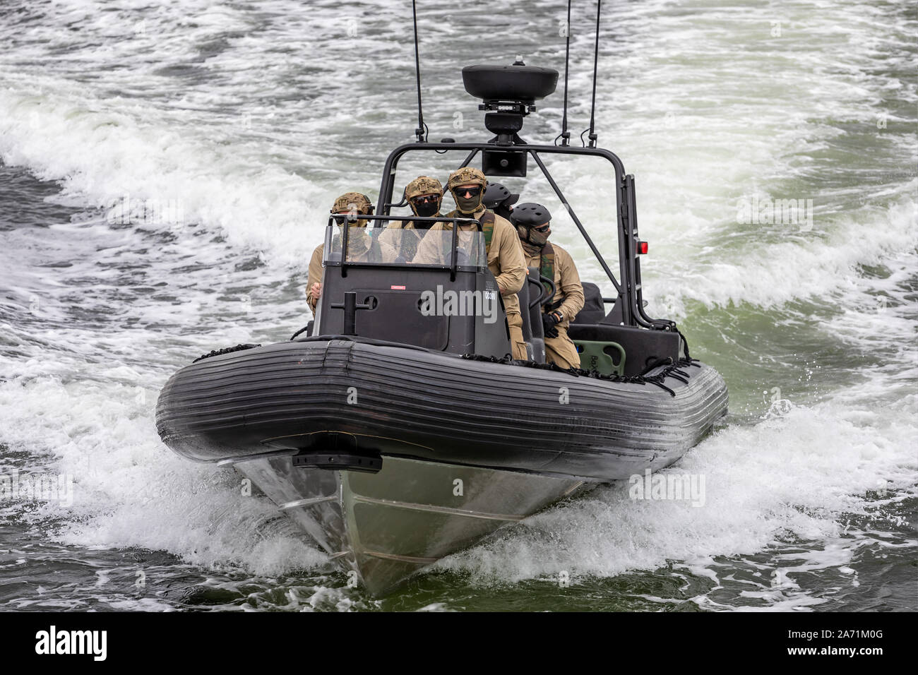 Close up of Water Police in camoflauge on high speed RIB on ...