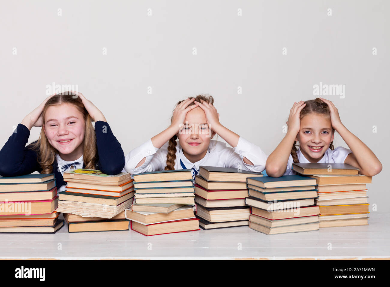 three girls at school with lots of books Stock Photo - Alamy