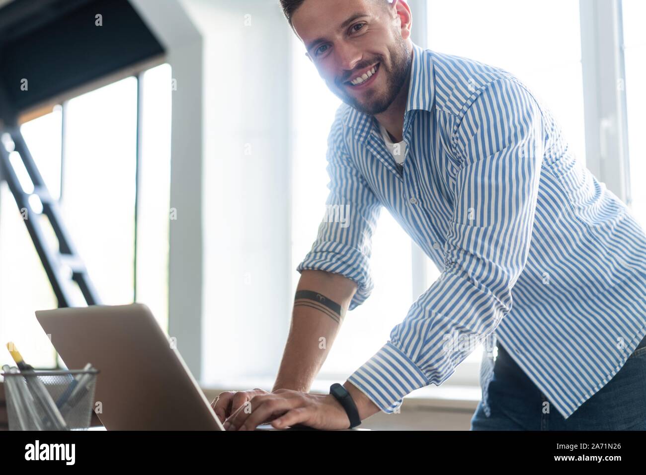 Man Working At Laptop In Contemporary Office Stock Photo - Alamy