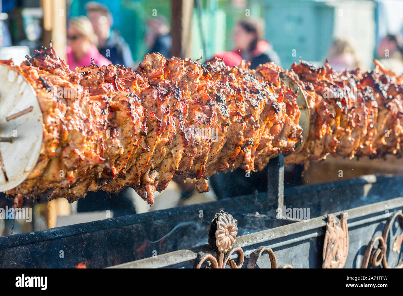 Large pieces of meat on a spit. Grilled skewered chicken on spit, a ...